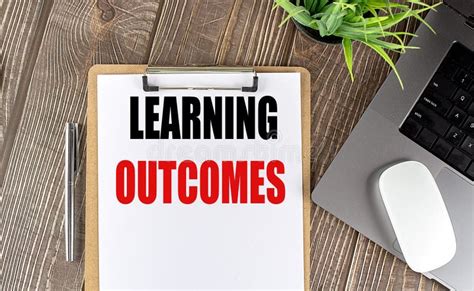 Learning Outcomes Text On Clipboard Paper With Laptop Mouse And Pen