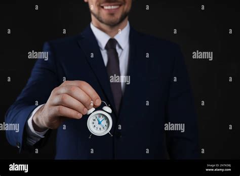 Happy Businessman Holding Tiny Alarm Clock On Black Background Closeup Time Management Stock
