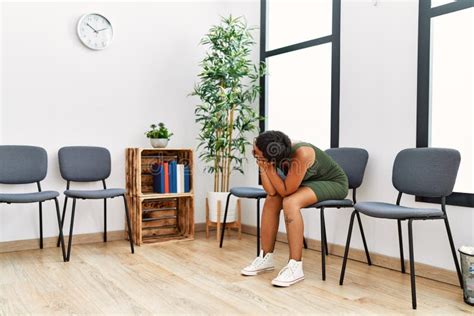 Young Hispanic Woman Desperate Sitting On Chair At Waiting Room Stock