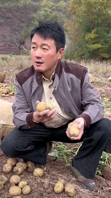 43 Year Old Tong Dawei Digs Potatoes In The Ground Wearing A Rustic