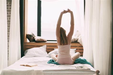Premium Photo A Beautiful Girl Sits On The Bed In The Early Morning