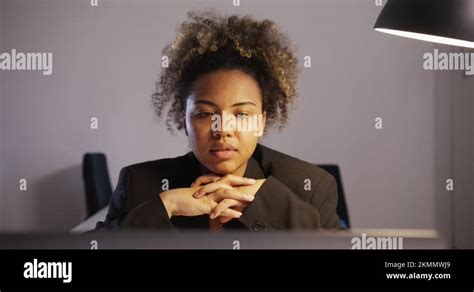 Black Girl In Suit Looks At Monitor Smiling And Wiggles Her Hands In