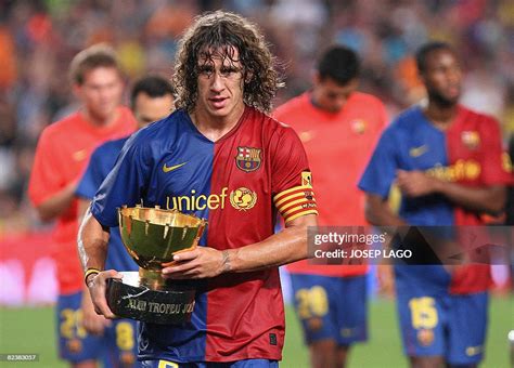 Barcelonas Captain Carles Puyol Holds His Champion Trophy In Their