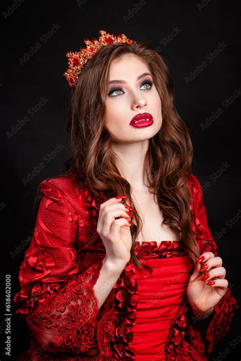 Portrait Of A Young Attractive Vampire Woman In A Red Dress In The Rococo Era With A Crown On