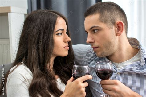 Close Up Of Young Couple With Glasses Of Red Wine Having Romantic Date