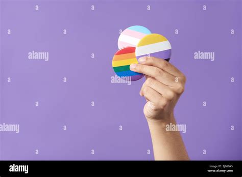 Hand Raising Three Pins With Rainbow Trans And Non Binary Flags On A