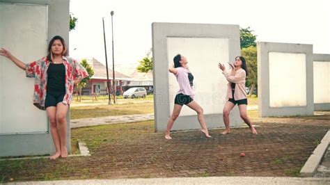 A Group Of Women Dancing Contemporarily Behind A Sad Woman In A Park