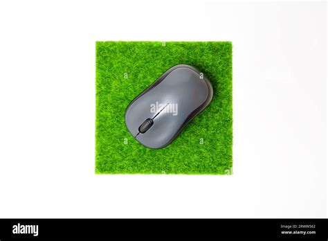 Top View Of A Computer Mouse Placed On A Tiny Square Patch Of Green Synthetic Grass Isolated On