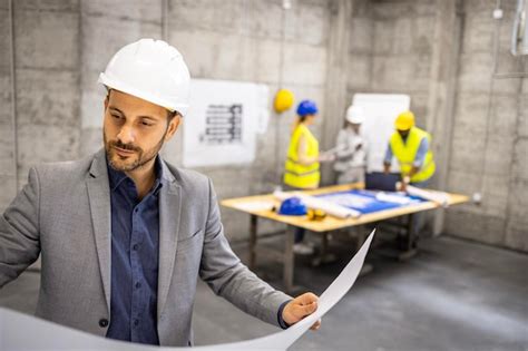 Premium Photo Architect Analyzing Building Plans And Blueprint At Construction Site