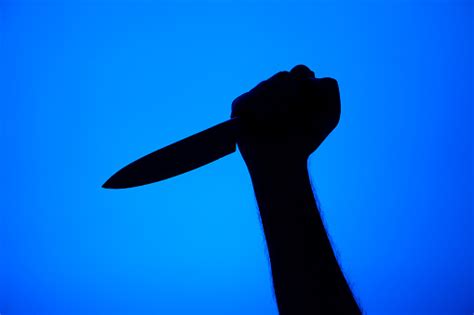 Knife Stabbing Gesture Silhouette Black On Blue Background Studio Shot