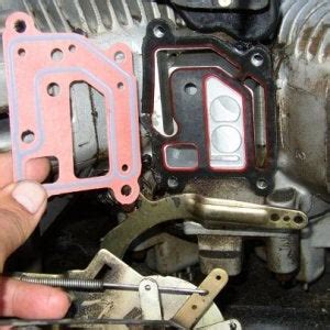 There is an aluminum breather cover bolted between the cylinders of the Kohler engine. It has ...