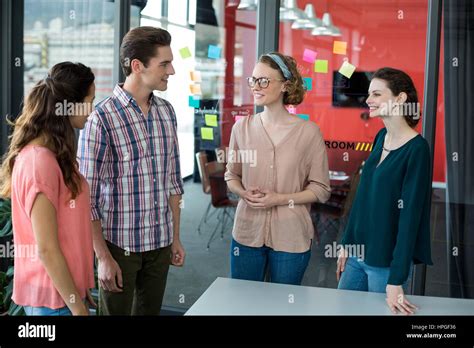 Smiling business executives discussing with each other in office Stock Photo - Alamy