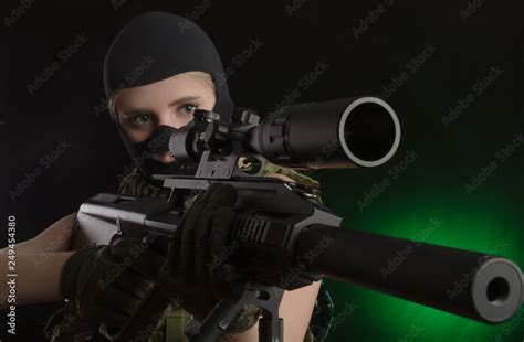 Girl In Military Special Clothes Posing With A Gun In His Hands On A