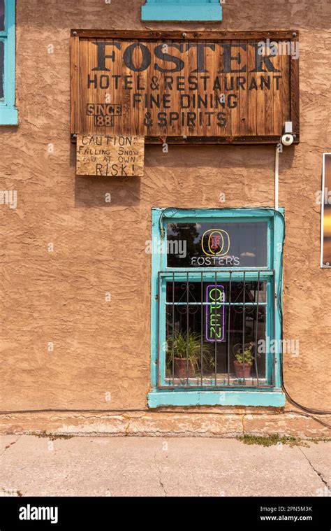 Beige Exterior Adobe Wall With Turquoise Window Frame And Sign For