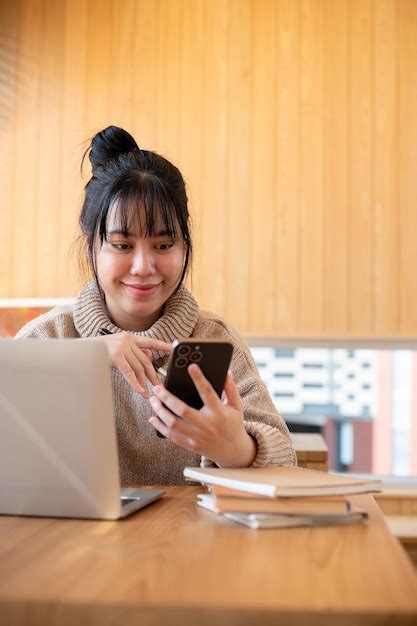 Premium Photo A Positive Asian Woman Is Reading Texts On Her Phone