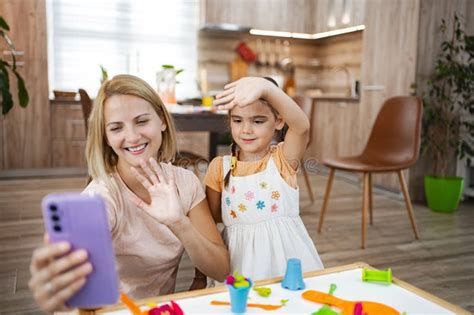 Mother And Daughter Enjoying A Playful Moment While Have A Video Call