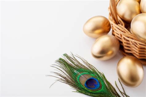 Premium Photo Golden Eggs In A Basket Decorated With A Peacock Feather