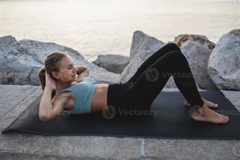 Teenager Girl Doing Abs Exercises Near The Sea Beach 14228341 Stock