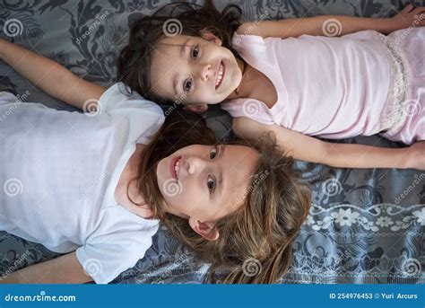 Best Buds For Life High Angle Shot Of Two Little Sisters Lying On A
