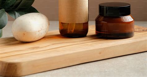 나무 보드에 녹색 잎을 가진 유기농 천연 화장품 호박색 유리 디스펜서 병 바디 크림 항아리 수제 비누 욕실 스파 미용 제품 포장 디자인 사진 Unsplash의