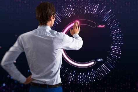 어두운 배경에 추상적 인 빛나는 최대 및 최소 스케일 홀로그램을 사용하는 매력적인 젊은 유럽 사업가의 뒷모습 볼륨 제어 및 미래 개념 가리키기에 대한 스톡 사진 및 기타