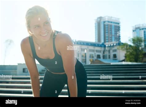 Young Smiling Blond Female Athlete In Tracksuit Looking Aside While