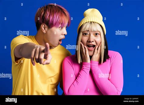 Asian Teenagers Pointing Finger At Camera While Expressing Surprise