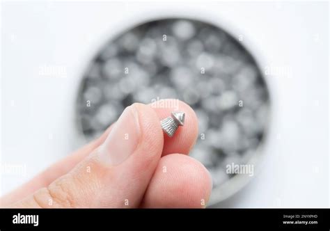Man Holding Up One Simple Small Metal Air Gun Pellet Object Macro