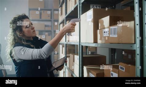 Female Warehouse Associate Scans Cardboard Box With E Commerce Online
