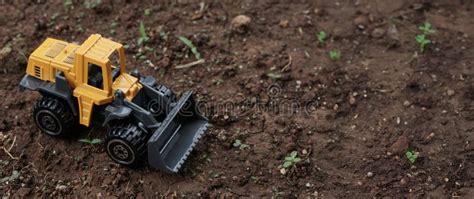 High Angle View Of Yellow Wheel Loader Or Tractor Toy With Soil Or