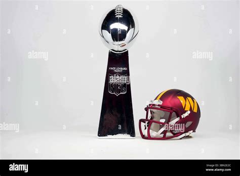 A Washington Commanders Helmet And Super Bowl Vince Lombardi Trophy On