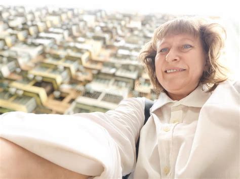A Middle Aged Woman Takes A Selfie Near The Monster House Attraction In