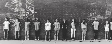 A Group Of People Stand In Front Of A Brick Wall Premium Ai Generated