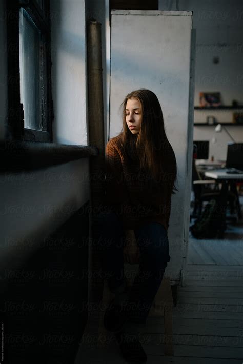 Female Leaning Head On Window Sill By Stocksy Contributor Alexandr