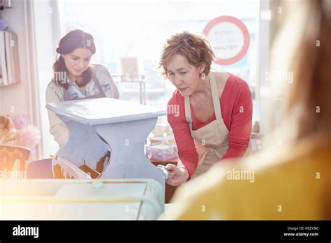 Female Artists Painting Wooden Bench Blue In Art Class Workshop Stock
