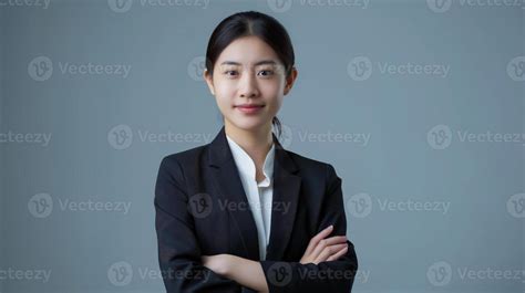 Confident Asian Businesswoman Posing With Arms Crossed Against Gray