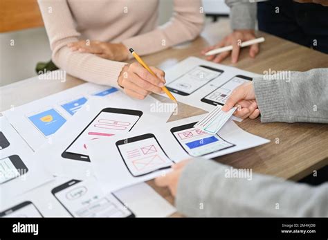 A Team Of Mobile App Developers And Designers Are Discussing And Brainstorming On Their New