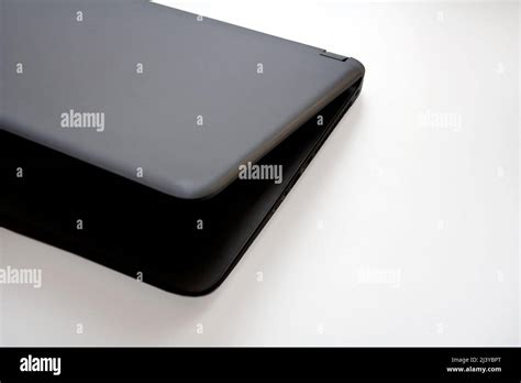 Right Side Detail Of Half Closed Slate Grey Laptop On White Background