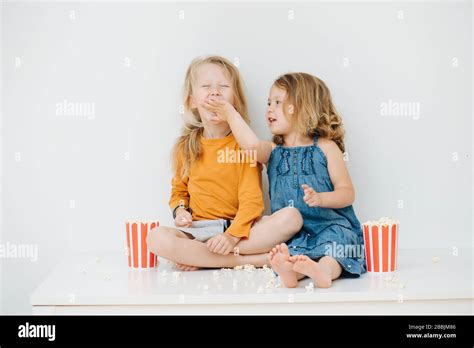 Sister Trying To Force Feed Her Brother With Popcorn He Laughs Stock