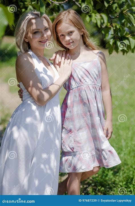 Beautiful Mom And Daughter Posing For Picture In Garden Stock Image