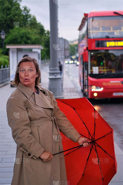 一名在旅游巴士旅行中打着红伞的妇女