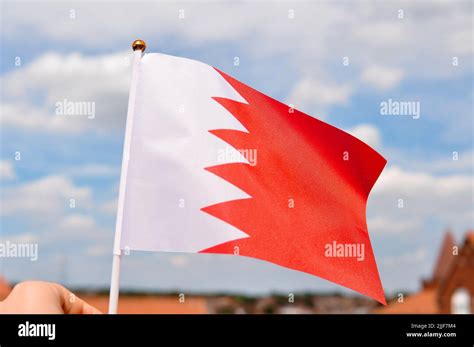 Close Up Of National Flag Of Bahrain On Blue Sky Background Red And