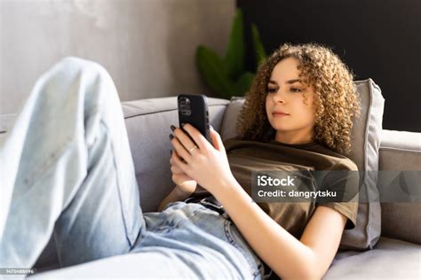Glückliche Junge Frau Die Ein Mobiltelefon Benutzt Während Sie Zu Hause