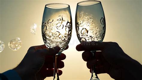 Two Champagne Glasses Clinking Bubbles Rising In The Golden Light Of