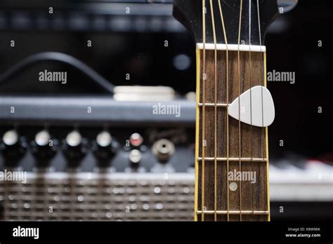 Acoustic Guitar Against Grand Piano Keys With Plectrum Musical Instruments Closeup Concept