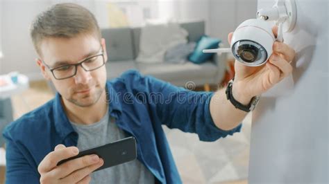 Young Man In Glasses Wearing A Blue Shirt Is Adjusting A Modern Wi Fi