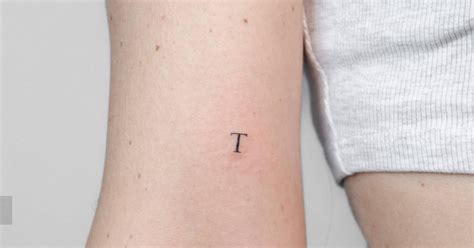Minimalistic Style Letter T In Serif Font Tattooed On