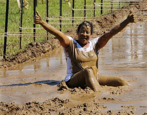 Mud Runner Sitting In The Mud With Both Arms Raised As In Victory And A Look That Says Hey