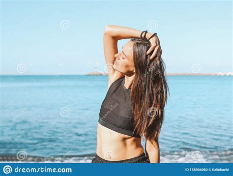 Young Slim Athletic Long Hair Sensual Woman In Sportswear On The Sea