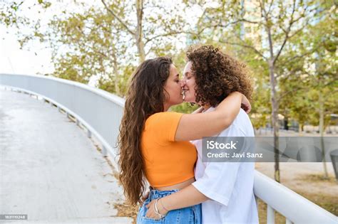 Young Lesbian Couple Hugging Kissing In A Public Park In The City Stock